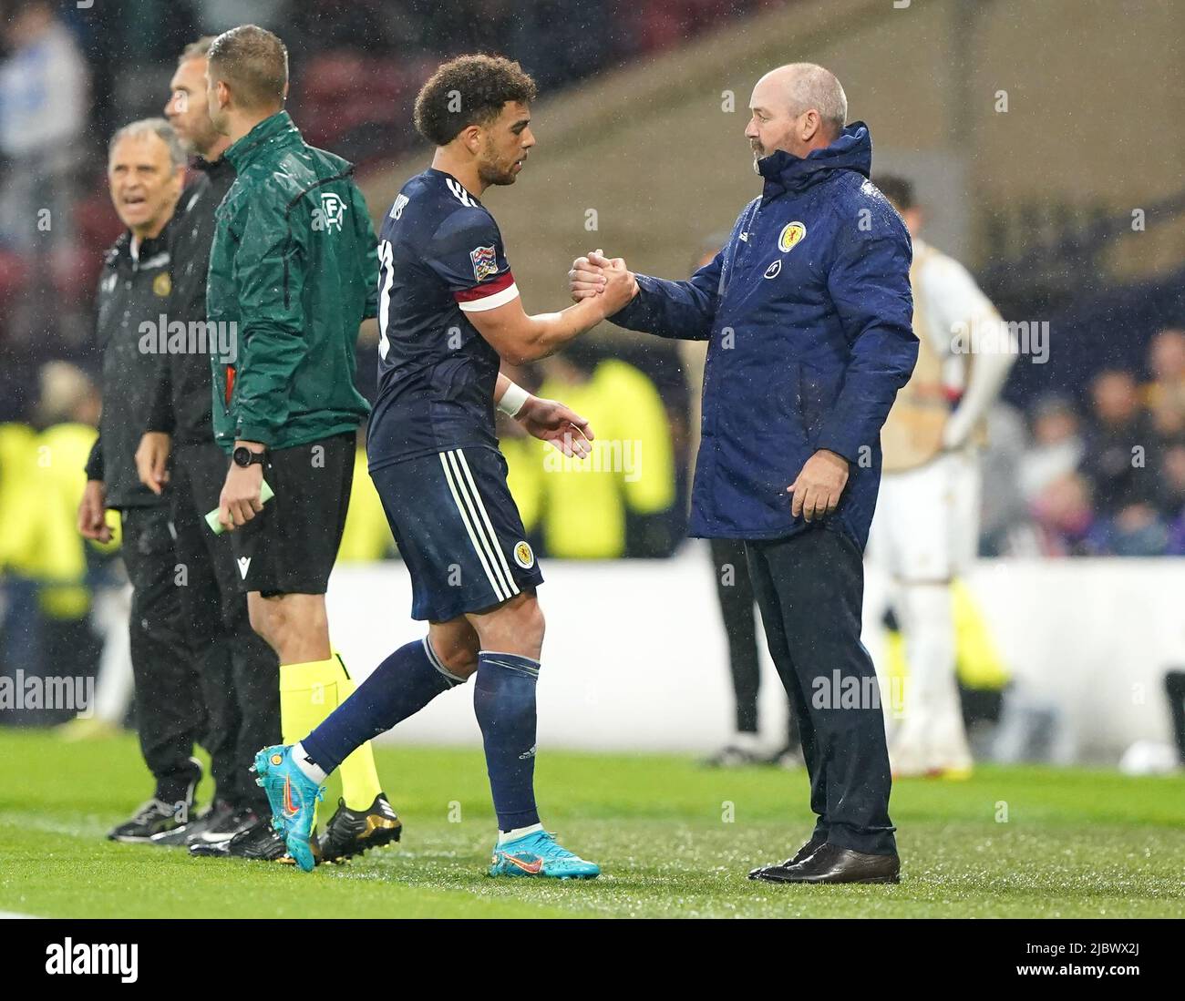 Scotland's Che Adams greets manager Steve Clarke as he leaves the field ...