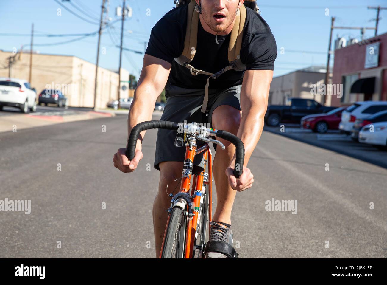 Close up of a young man riding a single speed bike to work in an urban ...