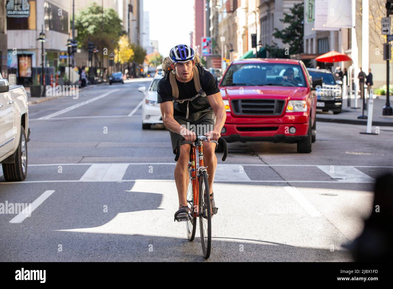 Bike Messenger out on the road for a delivery on a busy street Stock ...