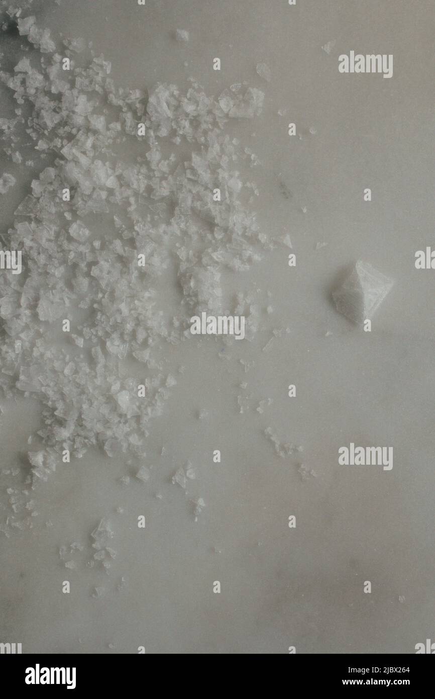 Maldon salt flakes with single pyramid shape salt crystal on white ...