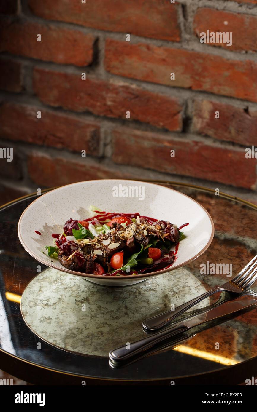 Salad with veal and tomatoes. Beef steak with raw vegetables mix side ...