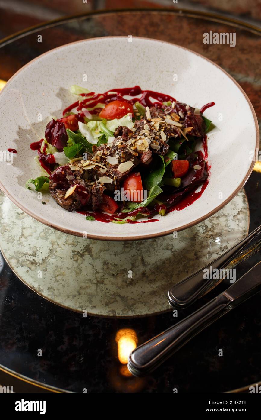 Salad with veal and tomatoes. Beef steak with raw vegetables mix side ...