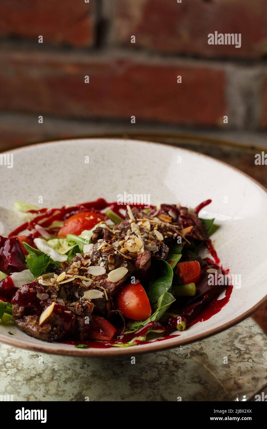 Salad with veal and tomatoes. Beef steak with raw vegetables mix side ...