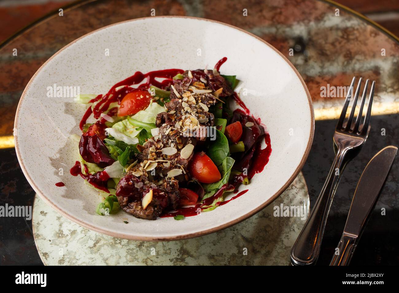 Salad with veal and tomatoes. Beef steak with raw vegetables mix side ...