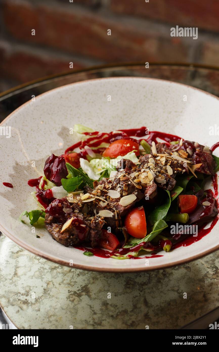 Salad with veal and tomatoes. Beef steak with raw vegetables mix side ...