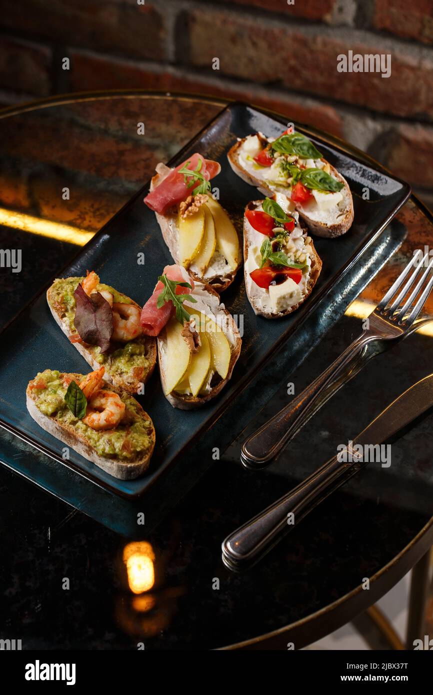 Bruschettas with vegetables. Start dishes with cherry tomatoes, avocado ...