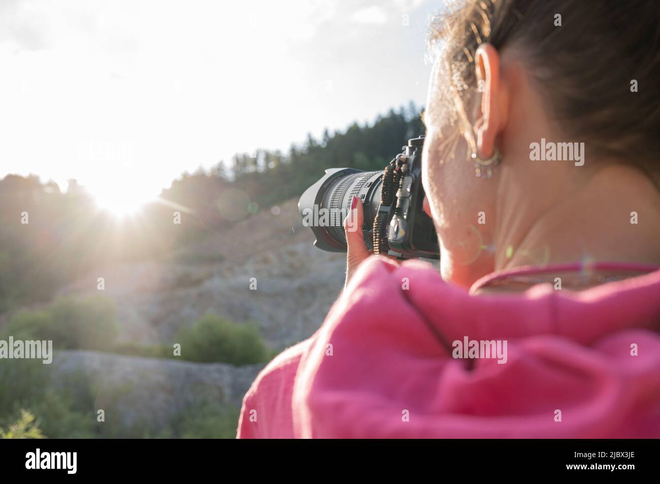 Over the shoulder view of a young female photographer taking photos of ...