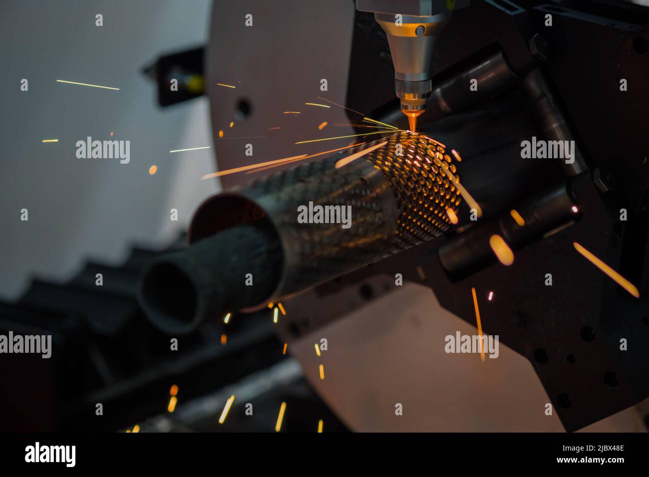 Laser cutting machine working with cylindrical metal workpiece with ...