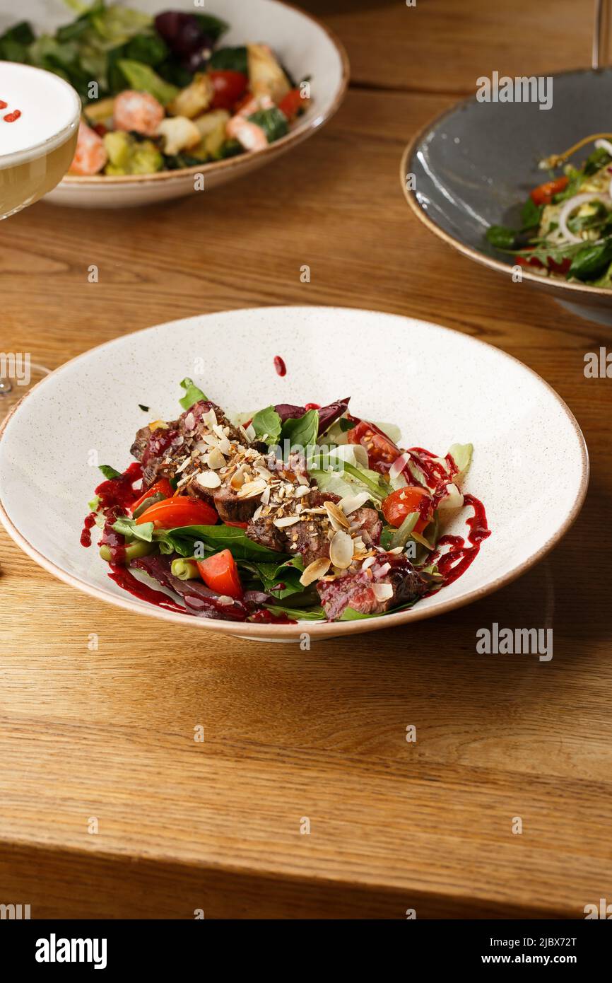 Salad with veal and tomatoes. Beef steak with raw vegetables mix side ...