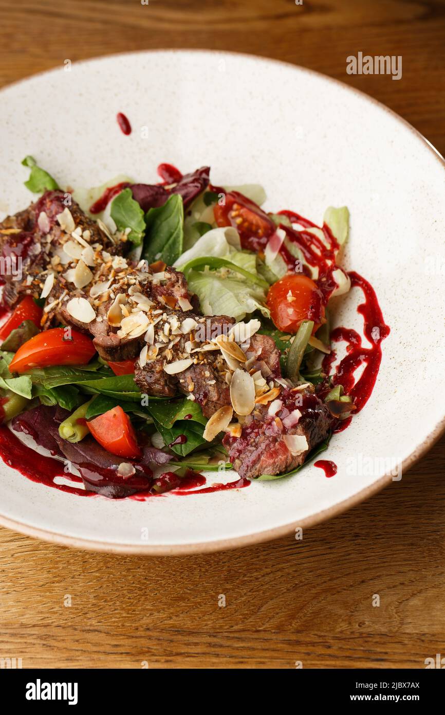 Salad with veal and tomatoes. Beef steak with raw vegetables mix side ...