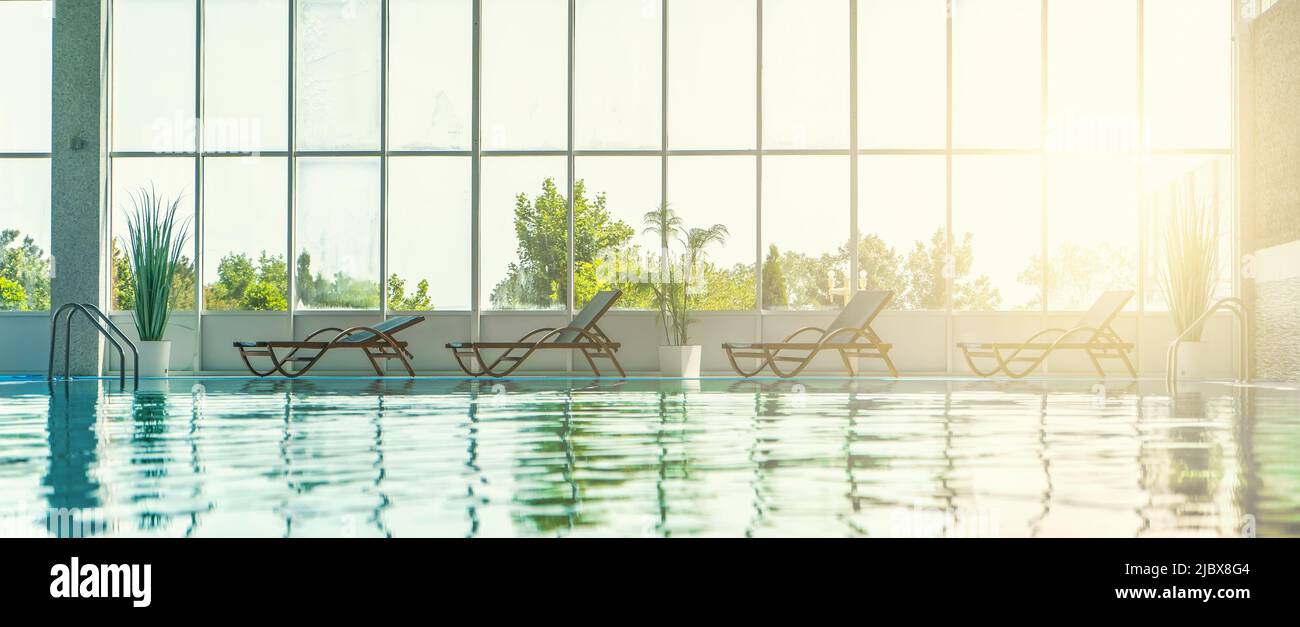Water surface in empty spa swimming pool with sun loungers for ...