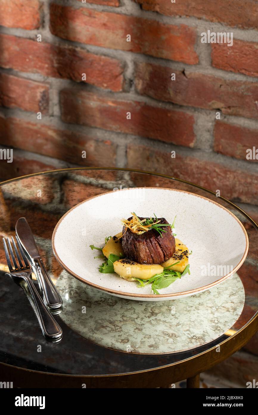 Grilled meat fillet steak medallion with green sauce, served with pear ...