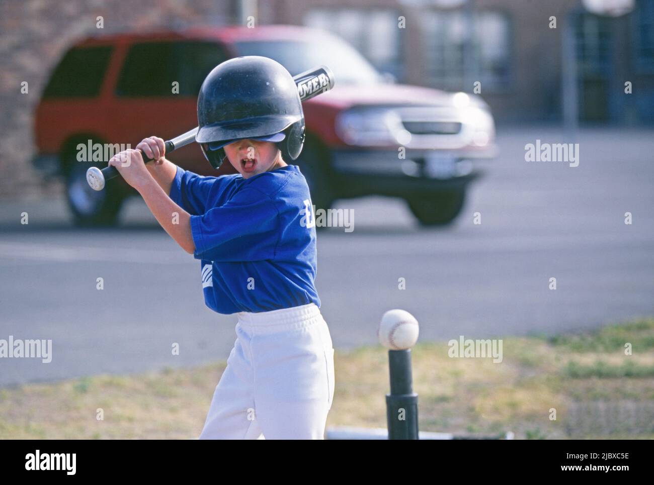 Young children play girls and boys Little League Softball at a school ...