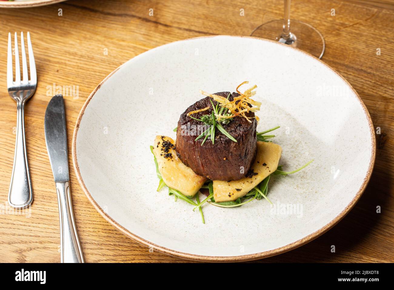 Grilled meat fillet steak medallion with green sauce, served with pear ...