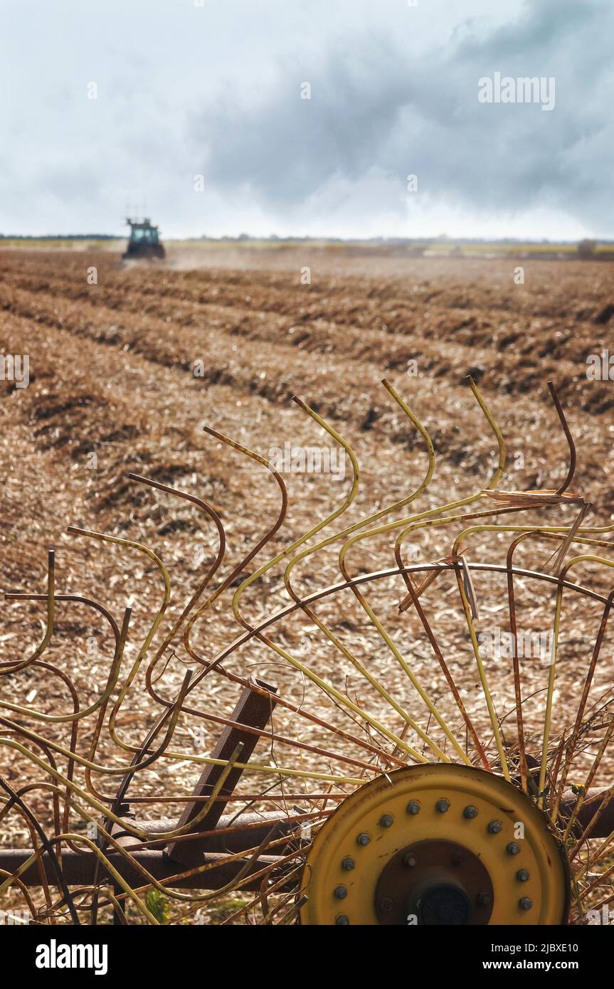 Tractor and wheel rake used to prepare field for planting of new crop ...