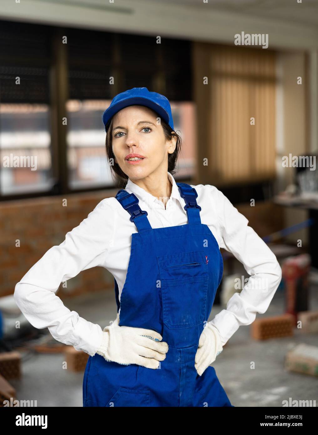 Woman construction worker posing inside house under renovation Stock ...