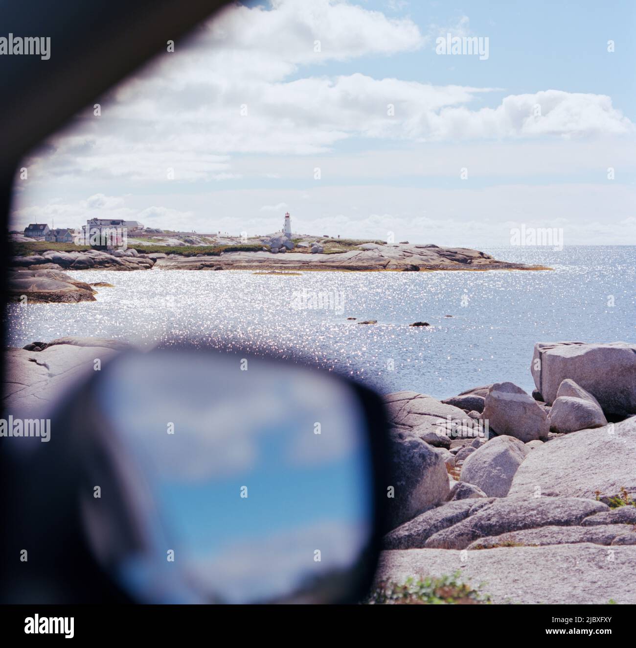 Lighthouse in the distance at the coast from the car, Peggy's Cove ...