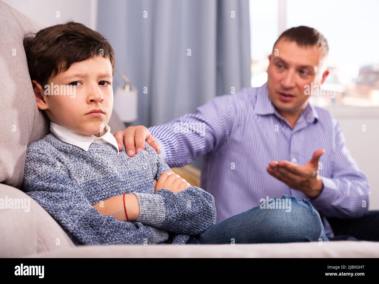 Offended boy and angry father having quarrel at home Stock Photo - Alamy