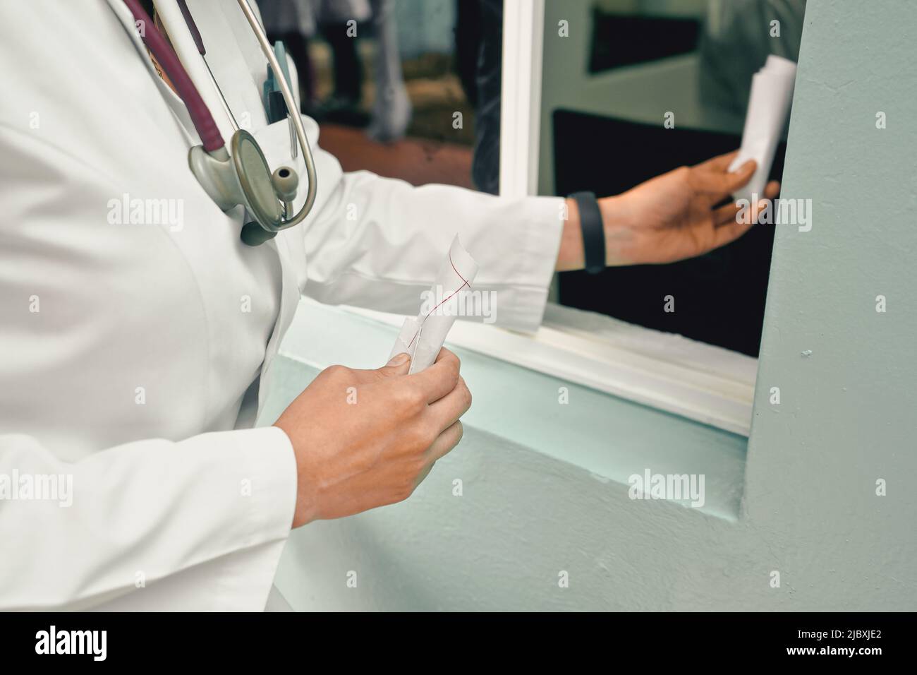 Latin female doctor handing out blood samples in a hospital laboratory ...