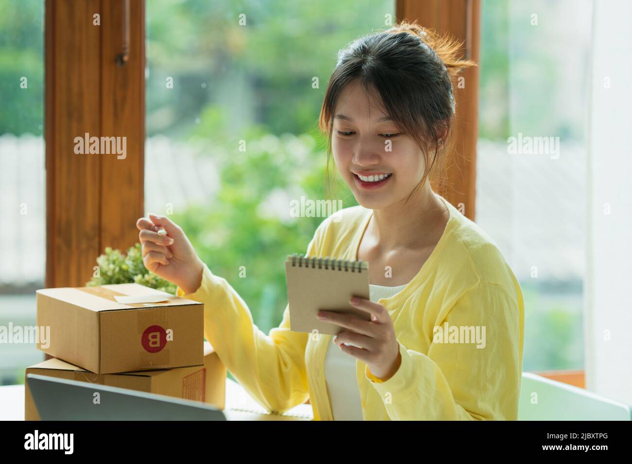 Young asian freelance packing boxes for commercial. SME e commerce ...