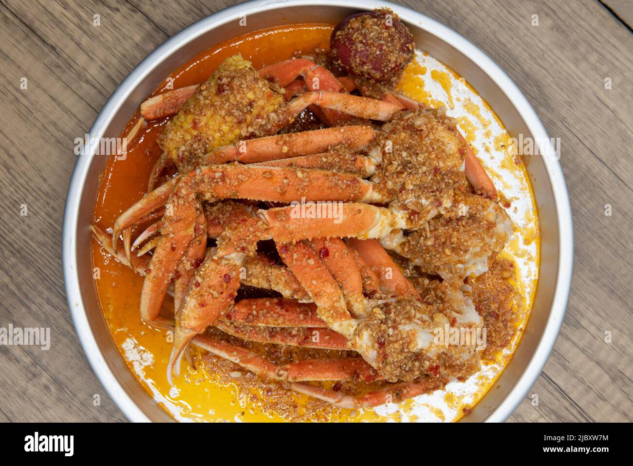 Overhead view of delicious buttery seasoned snow crab legs with corn on ...