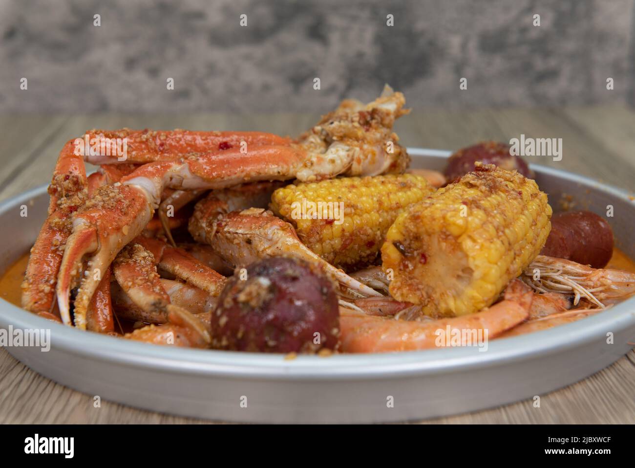 Delicious buttery plate of boiled snow crab legs with corn on the cob ...