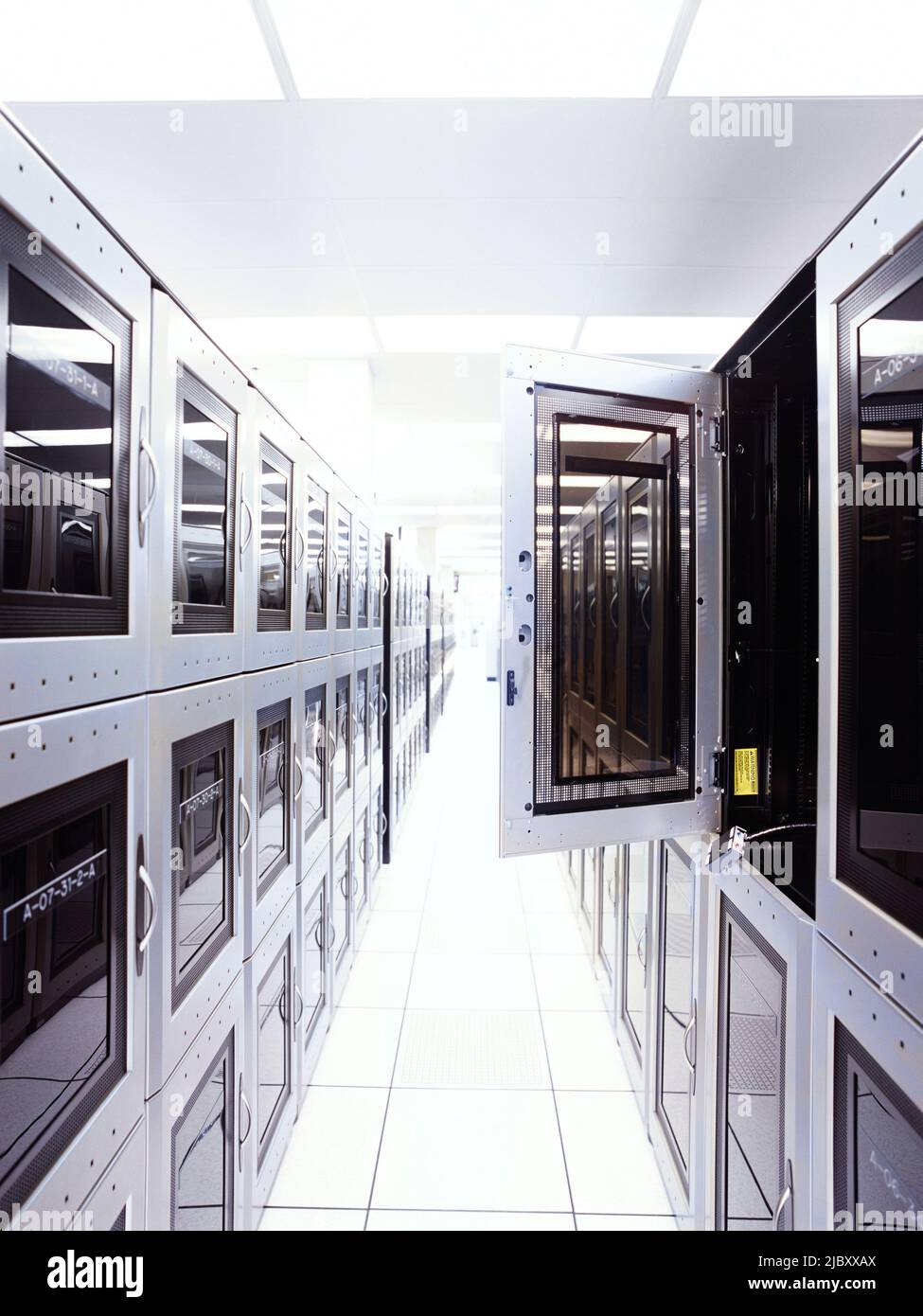 Large empty server room with one cabinet open in foreground Stock Photo ...