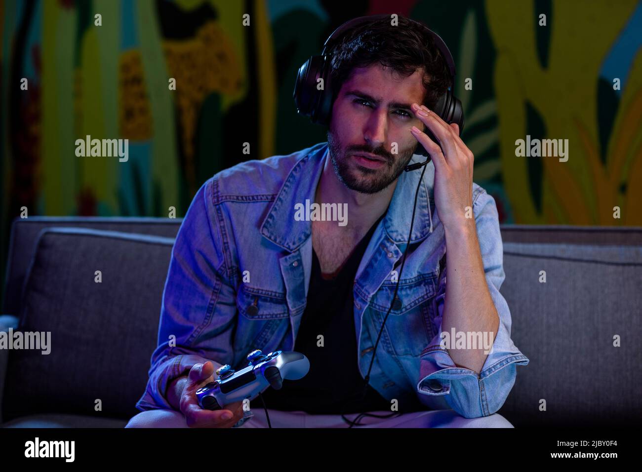 Focused and confused gamer playing on sofa at home Stock Photo - Alamy