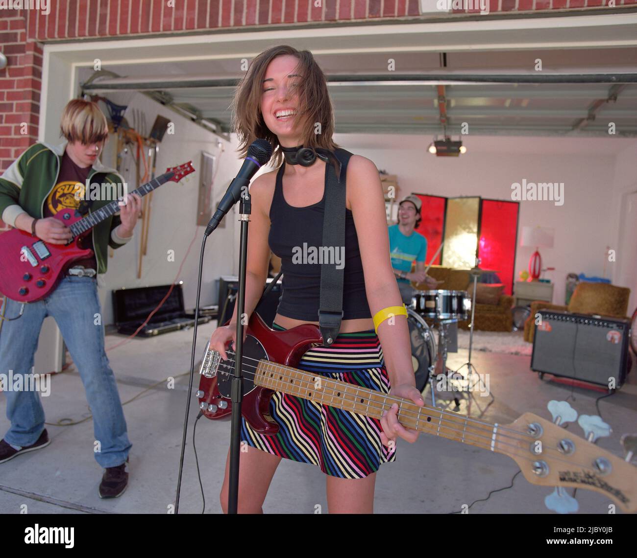 Group of Friends in garage band practicing in driveway in front of home ...