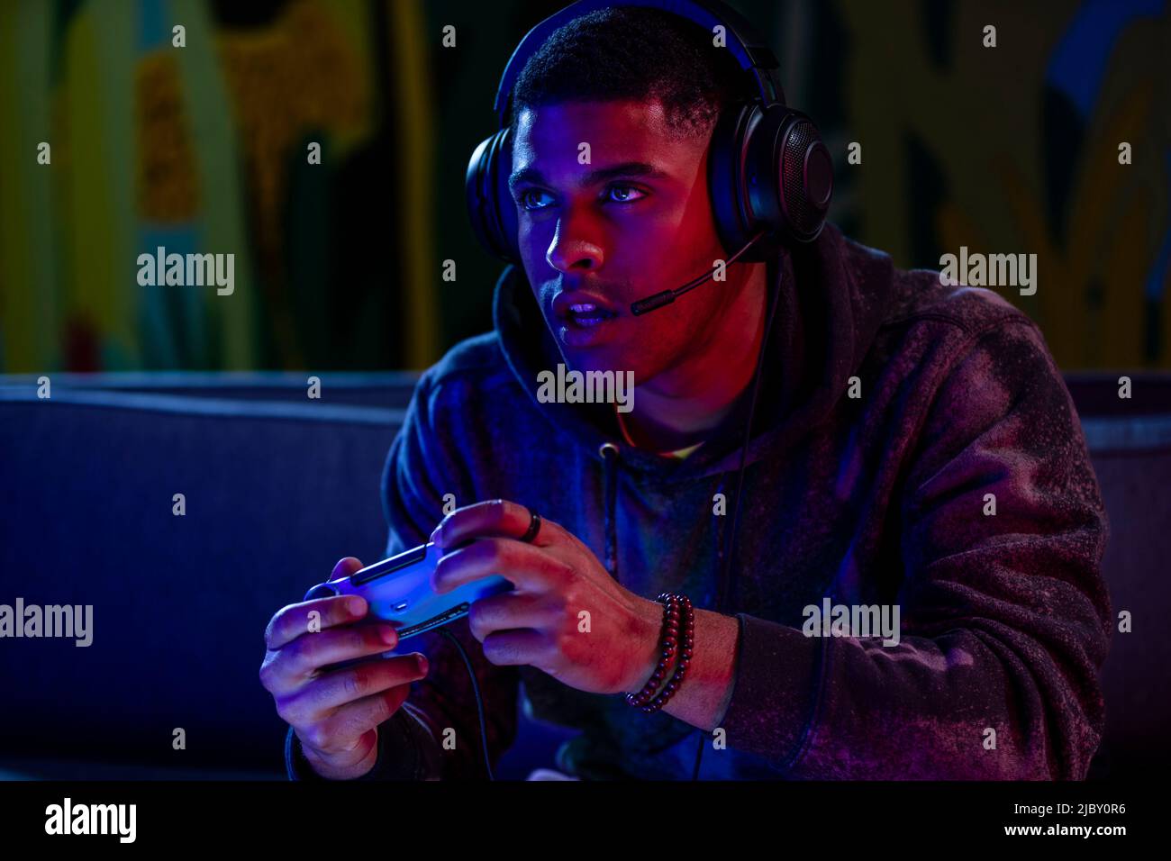 Man playing video game looking forward with intensity Stock Photo - Alamy