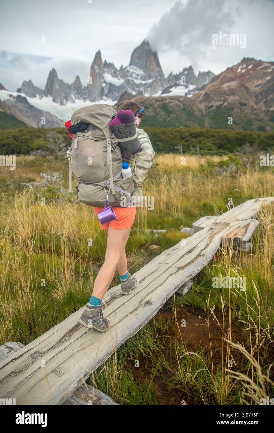 Hiker walking on a small footpath with Torres del Paine in the ...