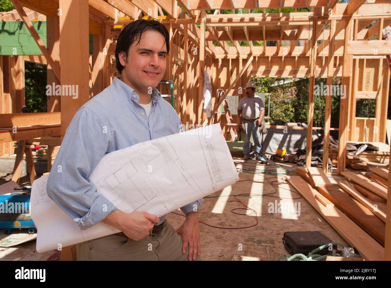 Contractor holding plans at residential construction site Stock Photo ...
