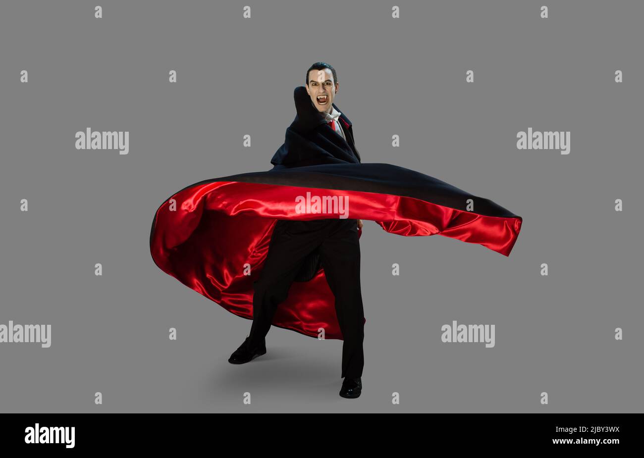 Portrait of a man dressed as a vampire against a gray background ...