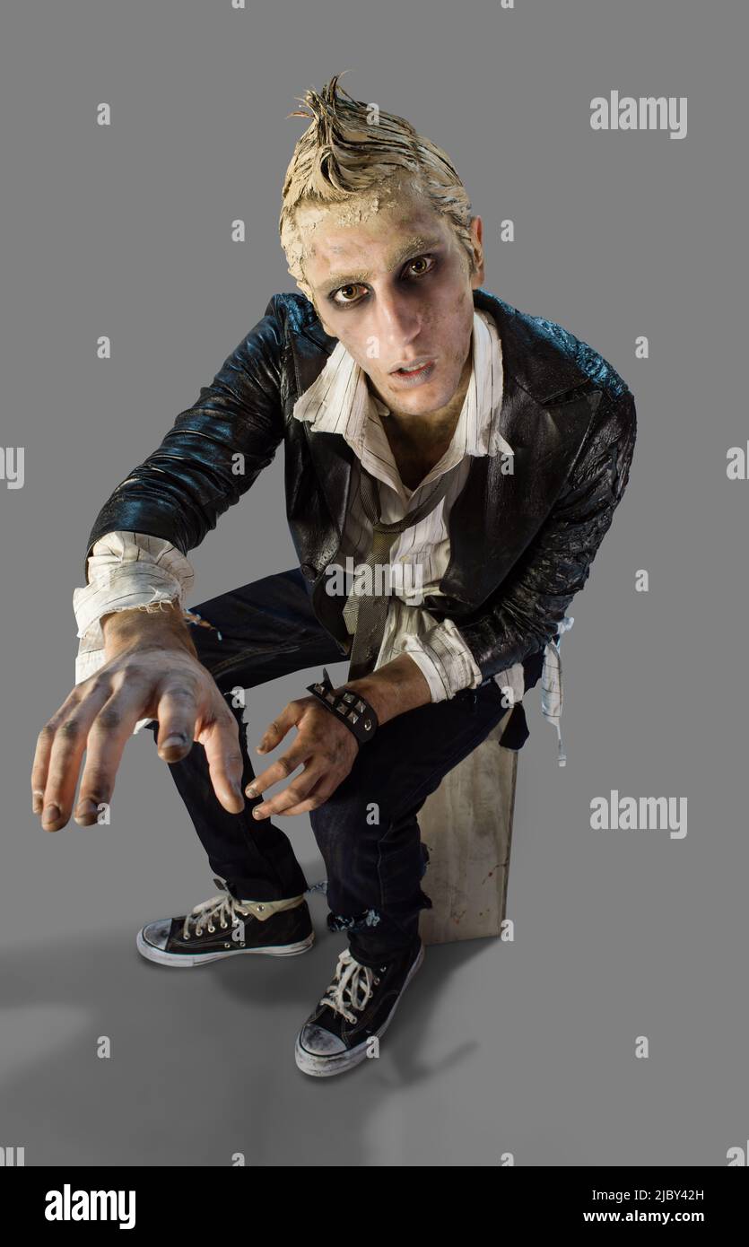 Wide close up shot of man dressed up in a zombie costume reaching out ...