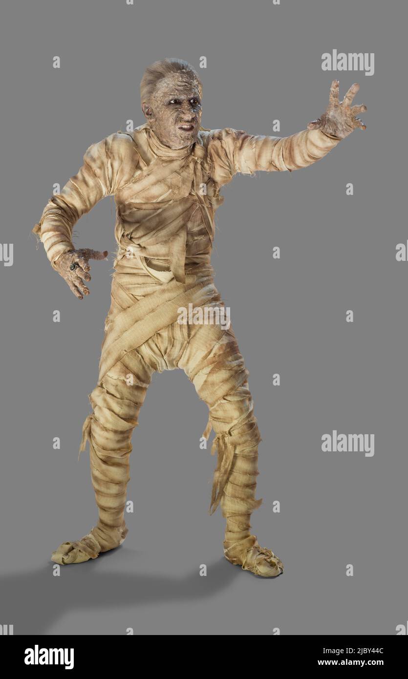 Full length portrait of a man dressed as a mummy wrapped in decaying ...