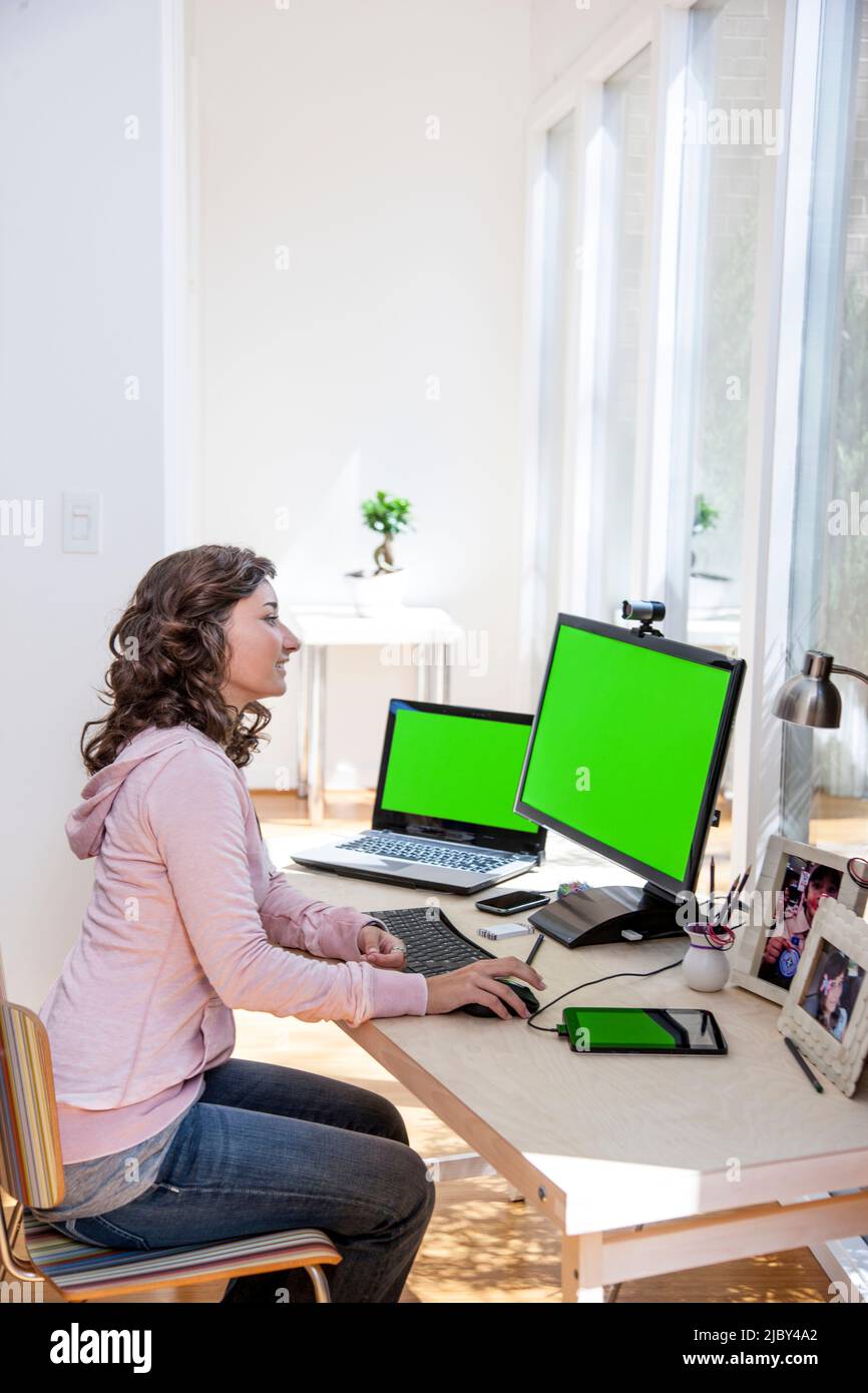 Young woman in home office on a video call, green screen Stock Photo ...