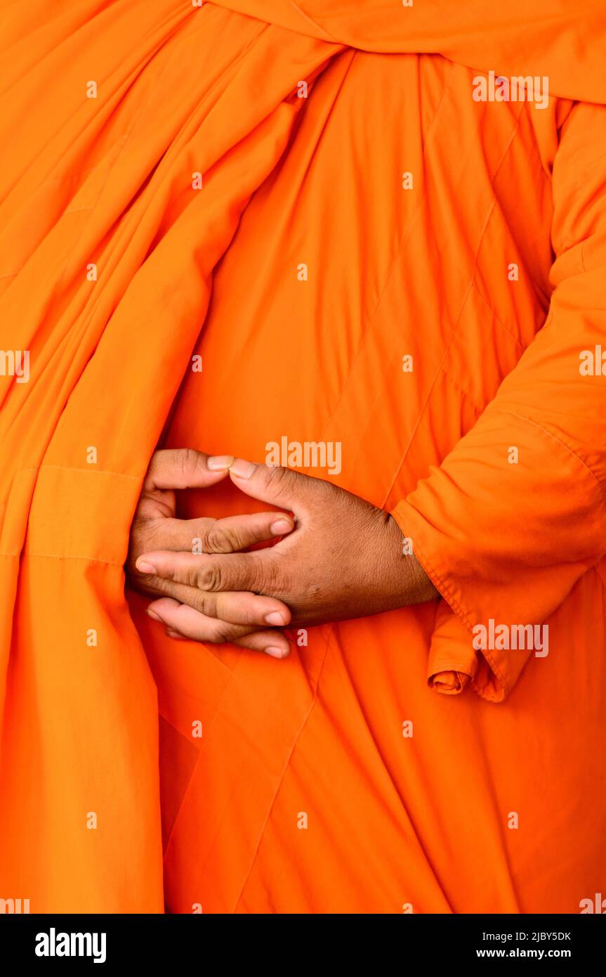 A Buddhist monk in Cambodia with folded hands and saffron robe Stock ...