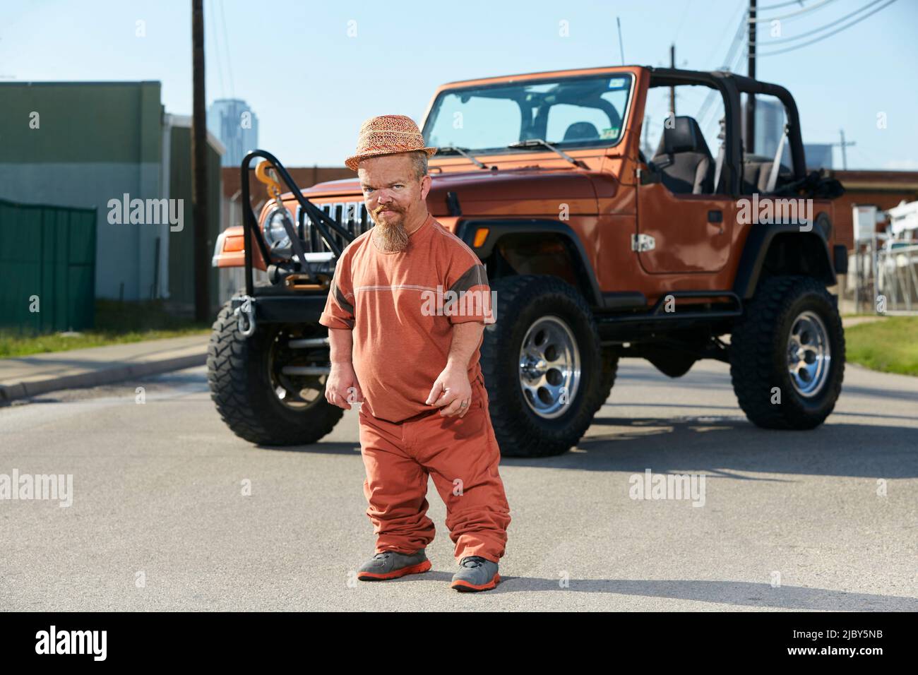 Full length portrait of male dwarf little person standing in street ...