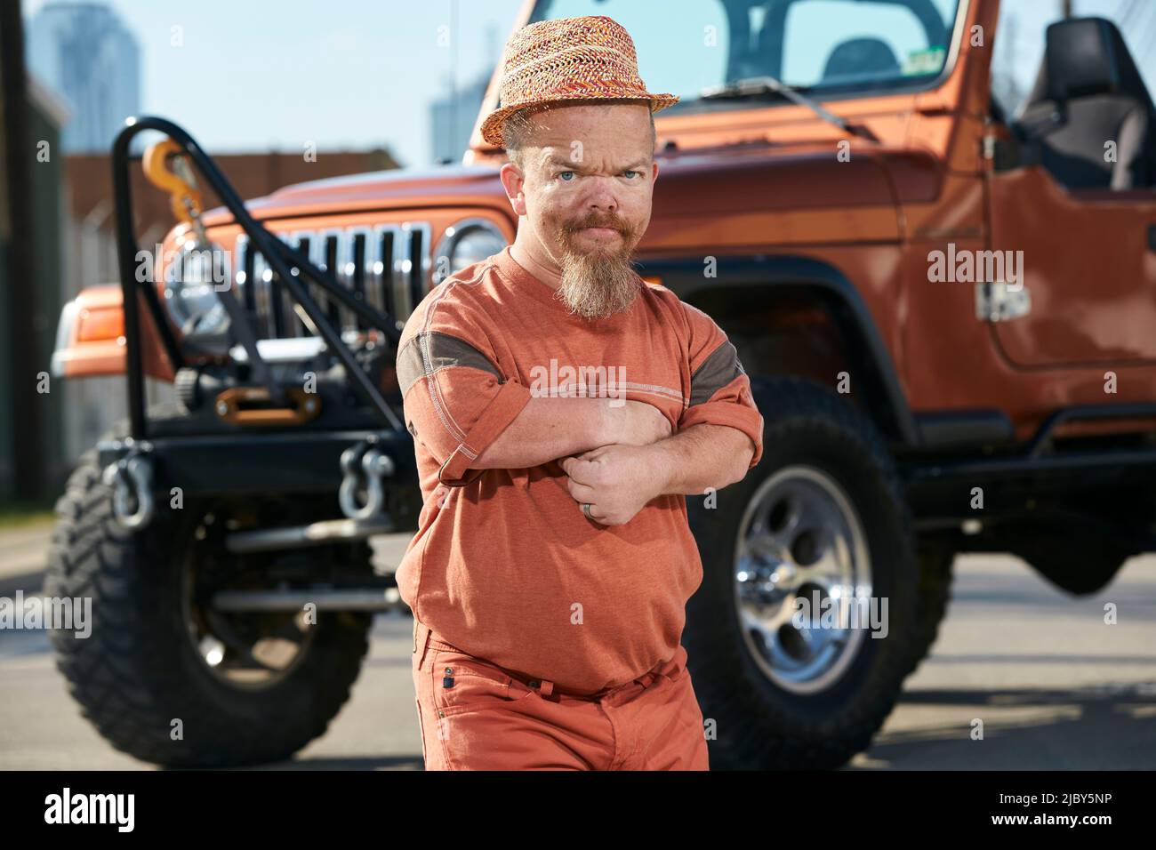 Portrait of male adult little person making tough face at camera with ...