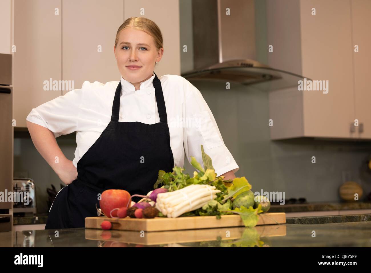 Low angle portrait of Chef Megan Gill in home kitchen looking at camera ...