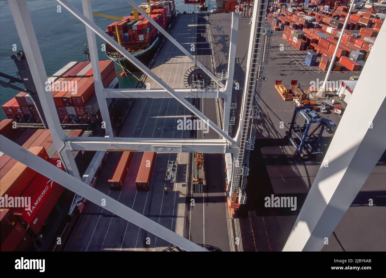 Looking down from crane at wharf full of shipping containers and loaded ...