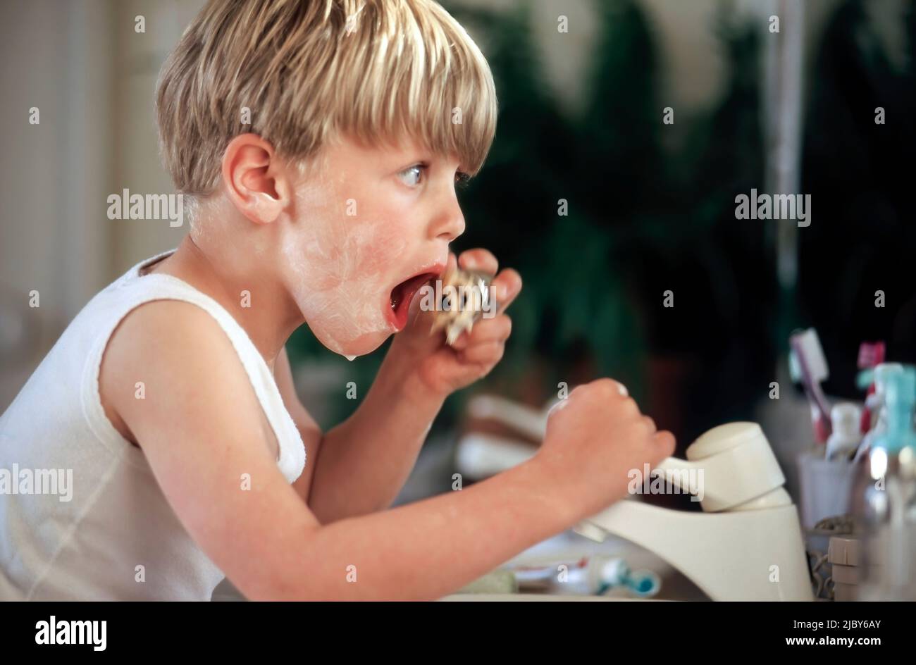 Little boy lathering soap on his face in the bathroom with shaving ...