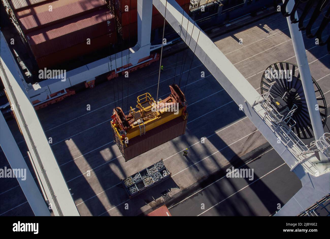 Looking down from crane at shipping container being hoisted for loading ...