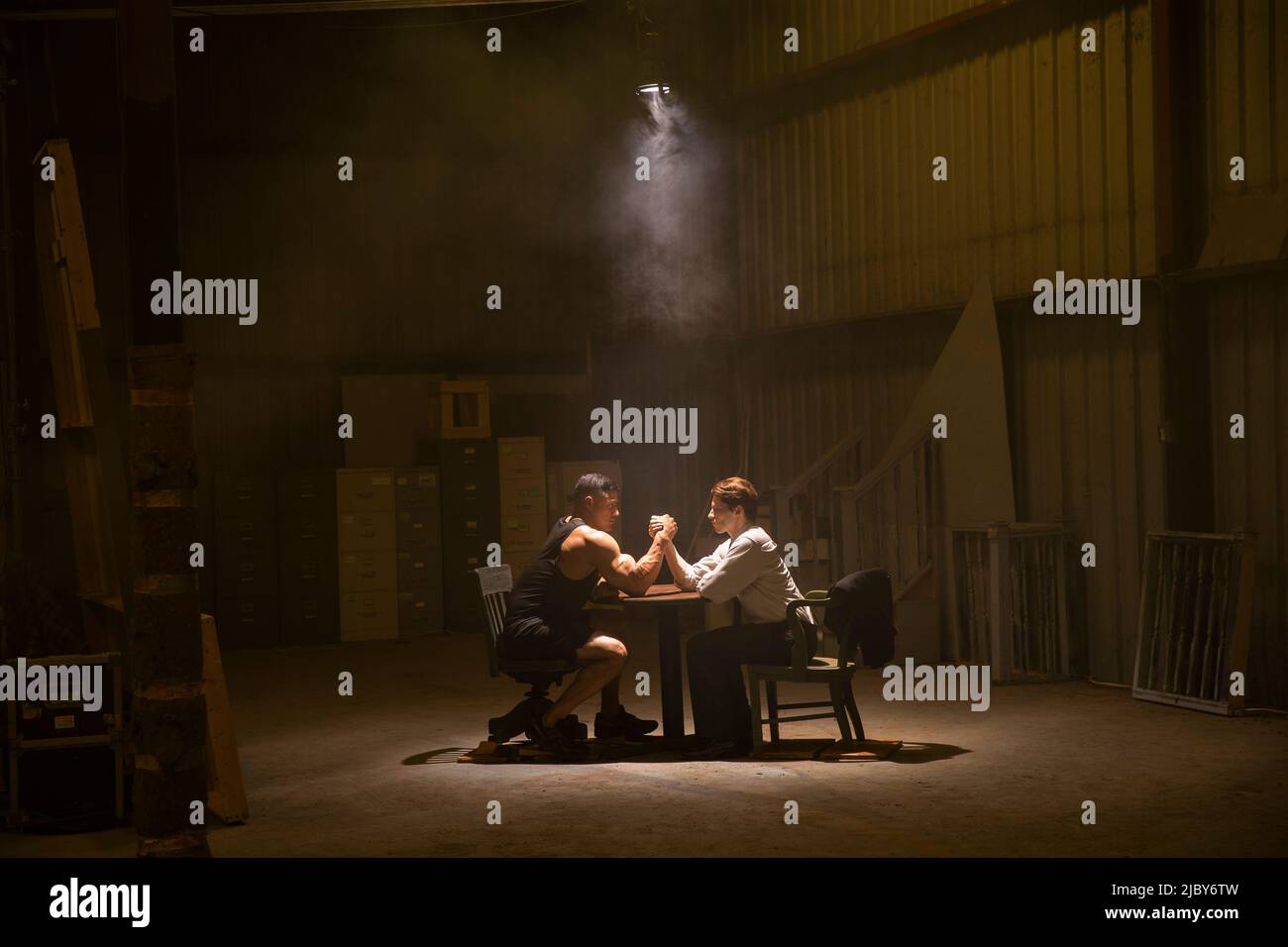 Two men preparing to have miss-matched arm wrestling contest in dingy ...