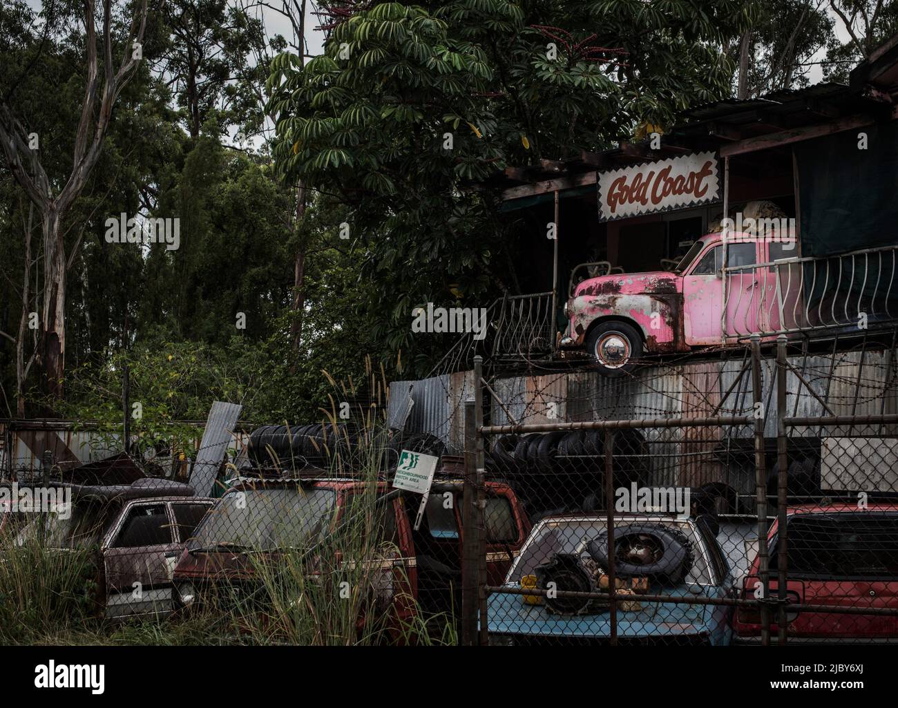 Car Wrecker Yard and pink building with car wreck perched on upstairs ...