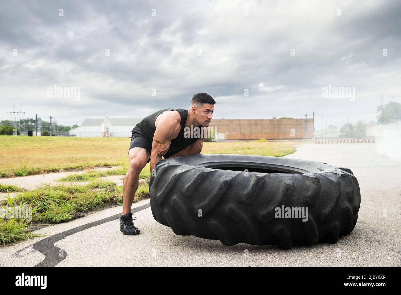 Muscular Hispanic man wearing tank top with “Strong” tattoo on his ...