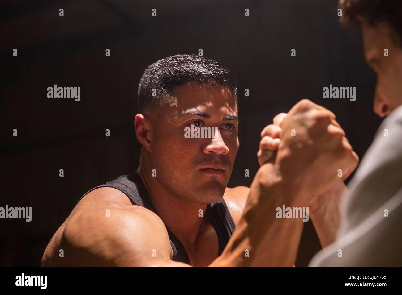 Two men preparing to have miss-matched arm wrestling contest in dingy ...