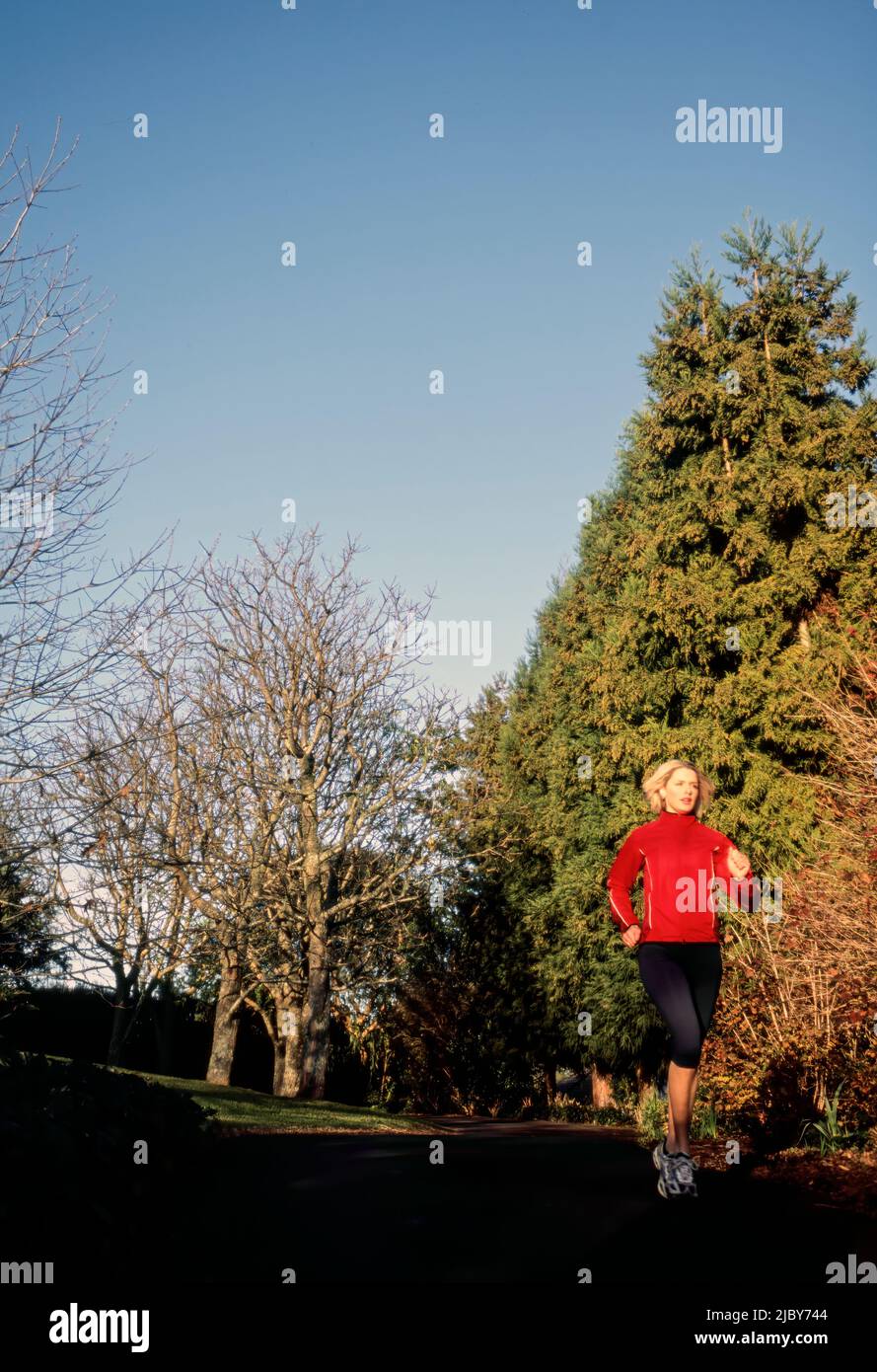 Woman running down driveway of home heading out for a run Stock Photo ...