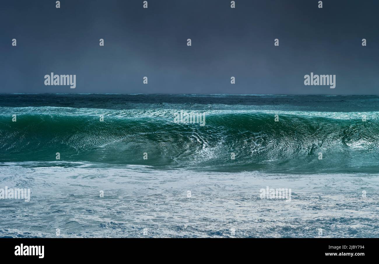 Huge wave curling over and breaking during cyclone Ola with stormy sky ...