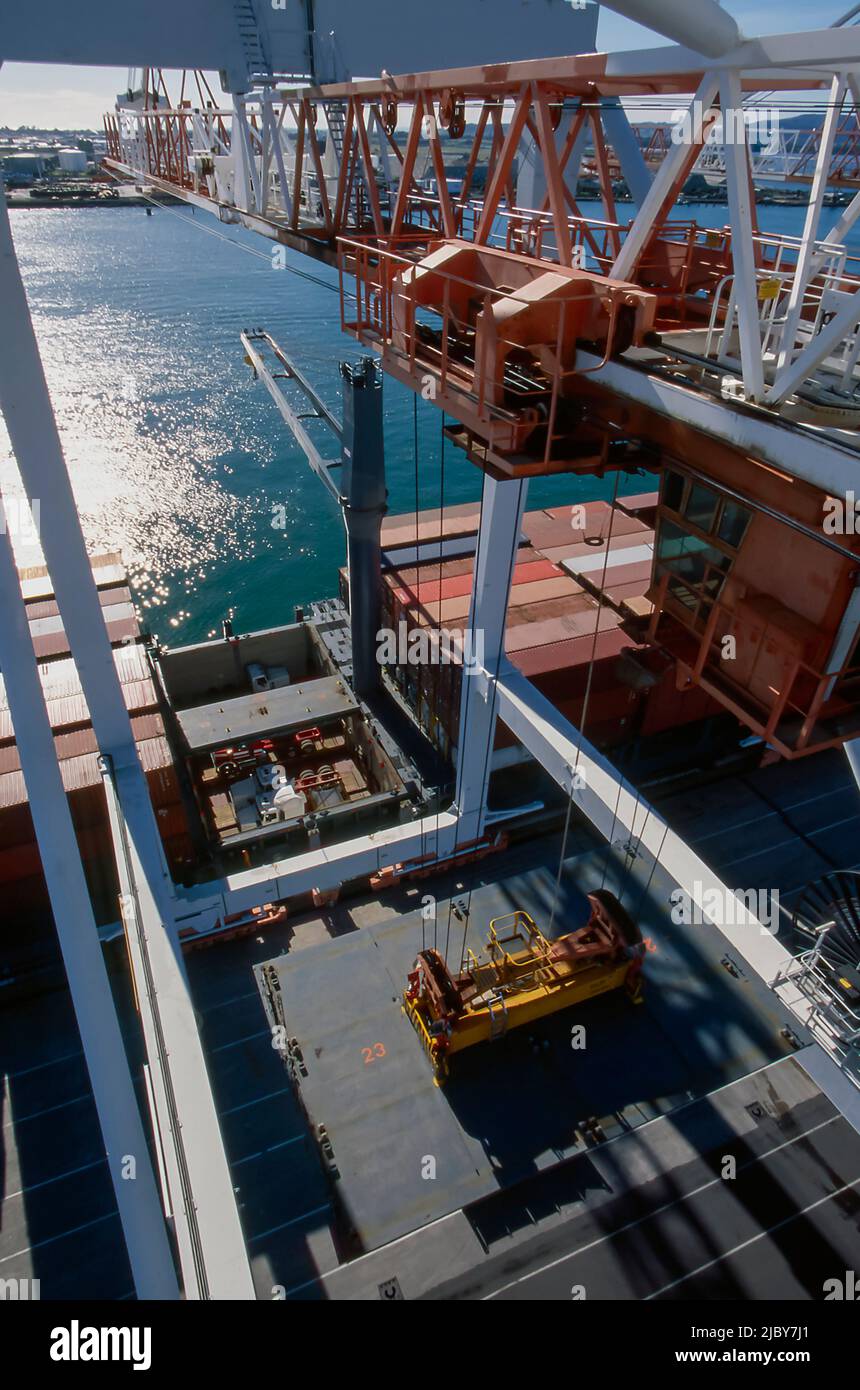 Looking from top of crane as it secures a shipping container to load ...